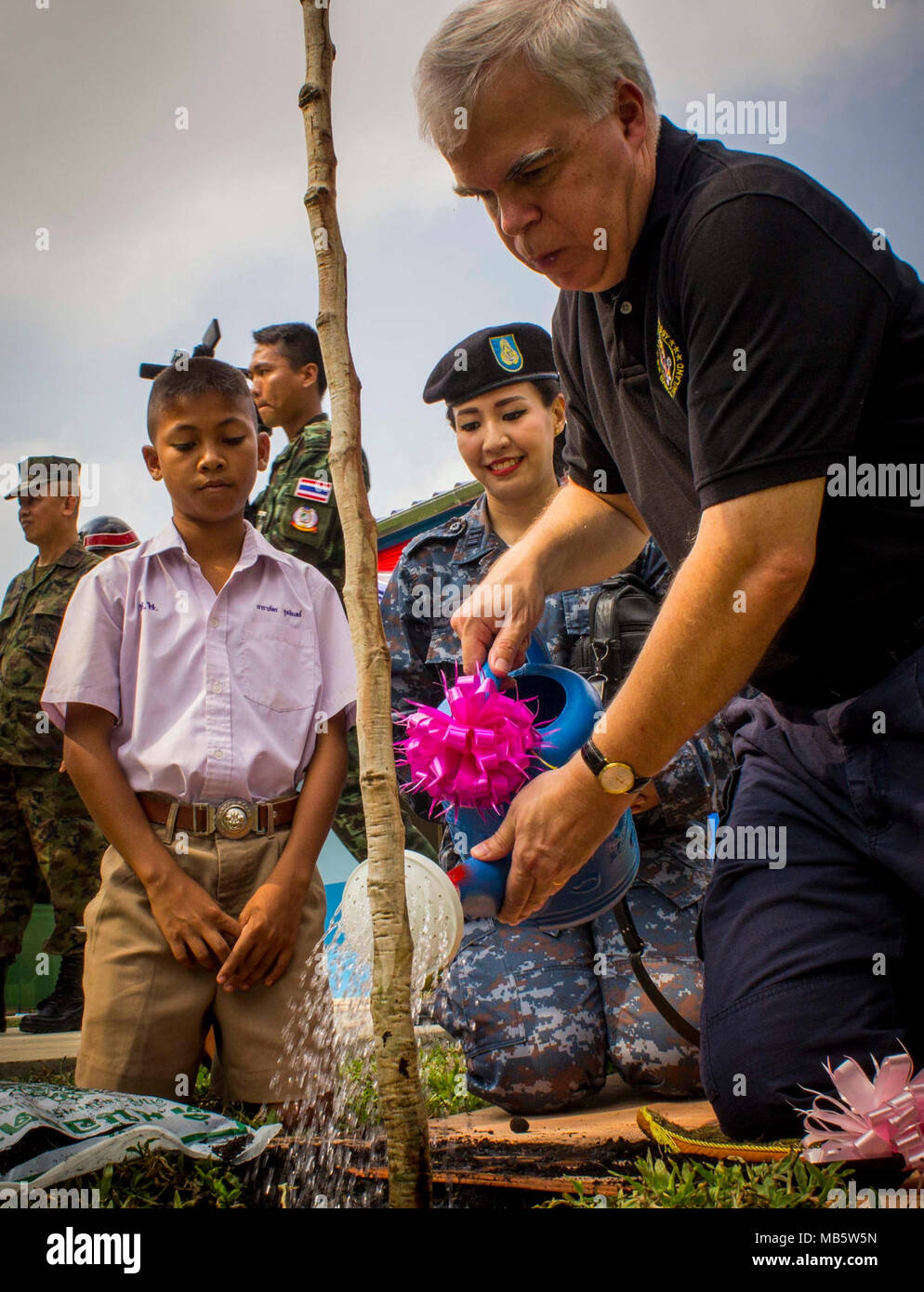 U.S. Deputy Chief of Mission Peter Haymond waters a tree planted during ...