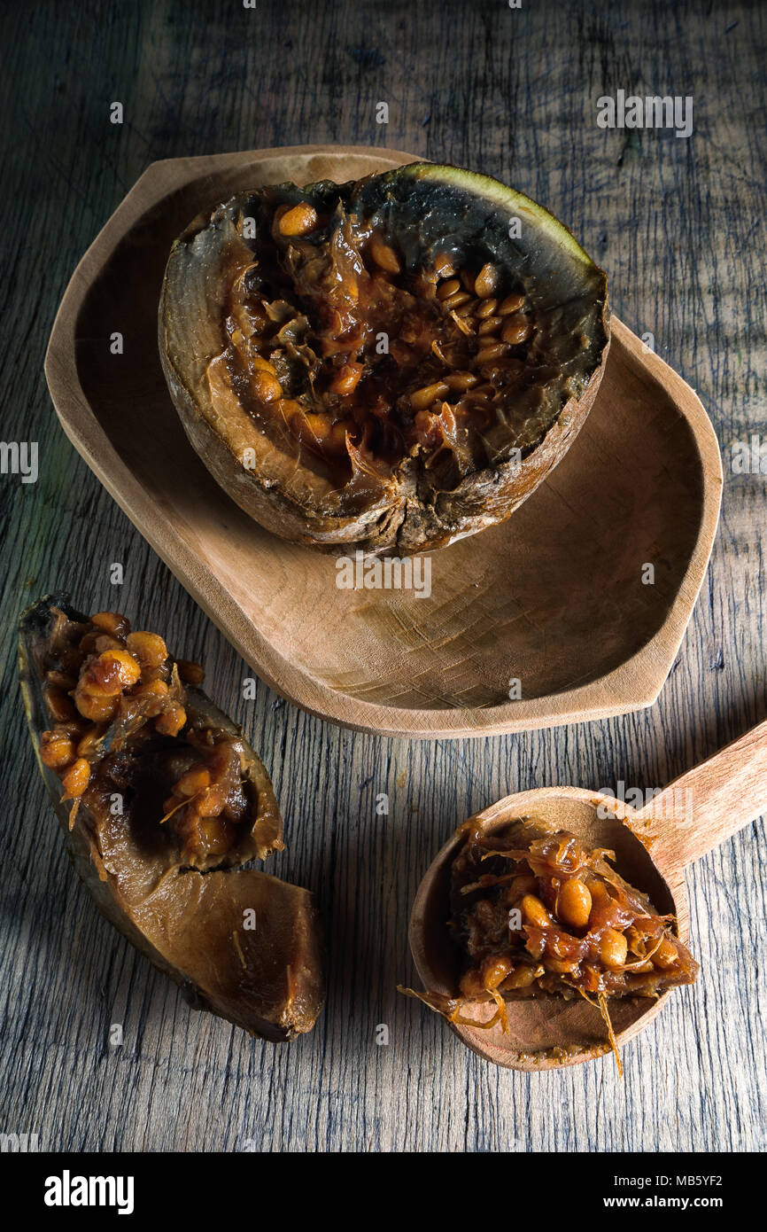 cut up borojo fruit, considered a superfood, on rustic wood background ...