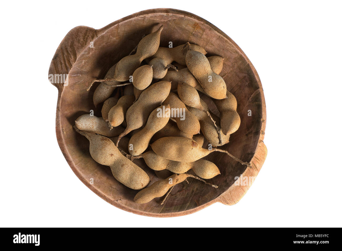whole tamarind fruits in round wooden bowl on white background Stock ...