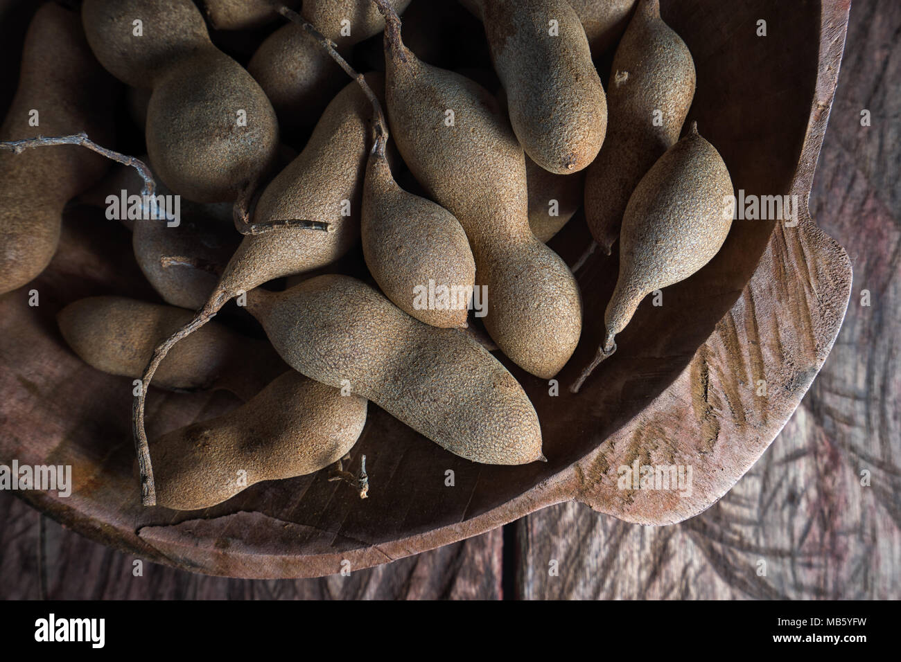 whole tamarind fruits in wooden bowl on rustic background Stock Photo ...