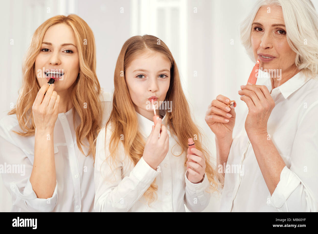 Beautiful three ladies applying lip makeup together Stock Photo - Alamy