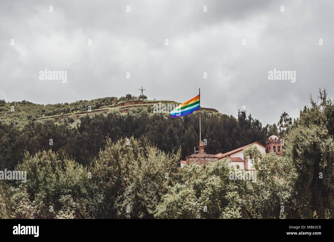 Indigenous rainbow flag of South America flies high above a building in ...