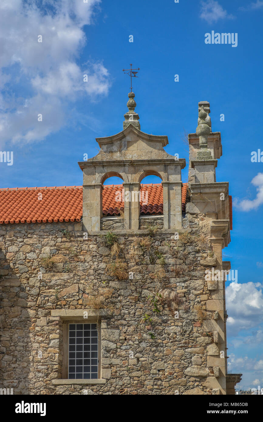 stone medieval religious building with orange tiles on roof and blue ...