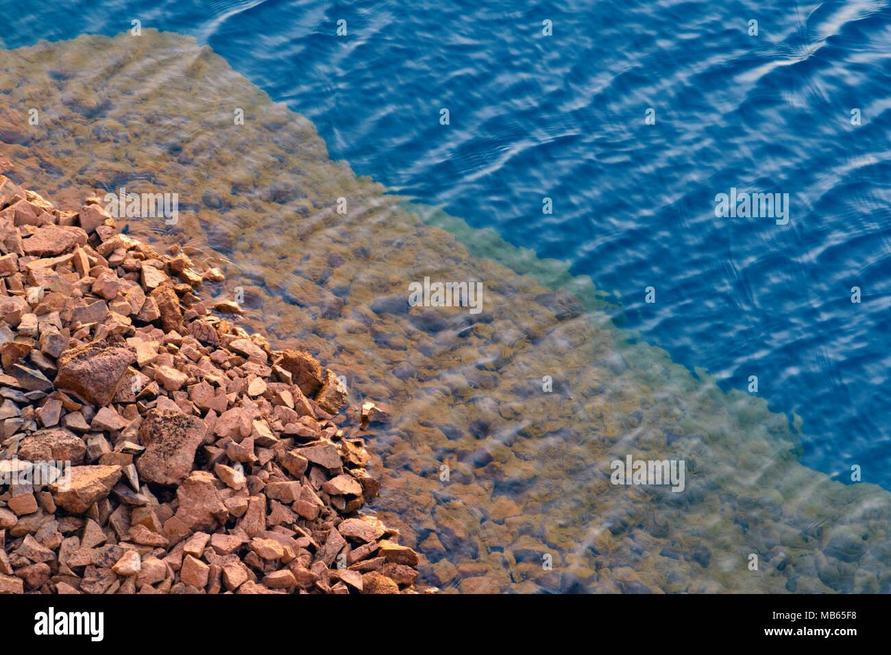 nature backgrounds fresh blue water color on the edge of rocky lake ...