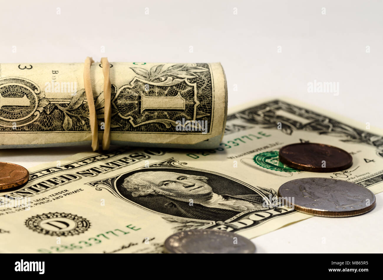 still life with a dollar bill rolls over a white background. symbol of ...
