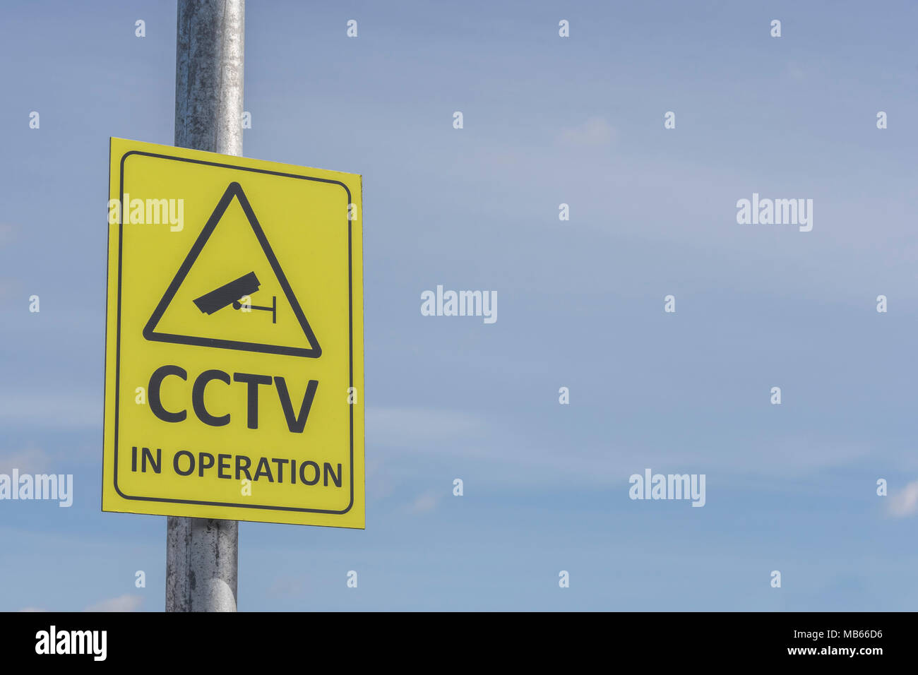 CCTV security camera in operation yellow warning sign - Watching over ...