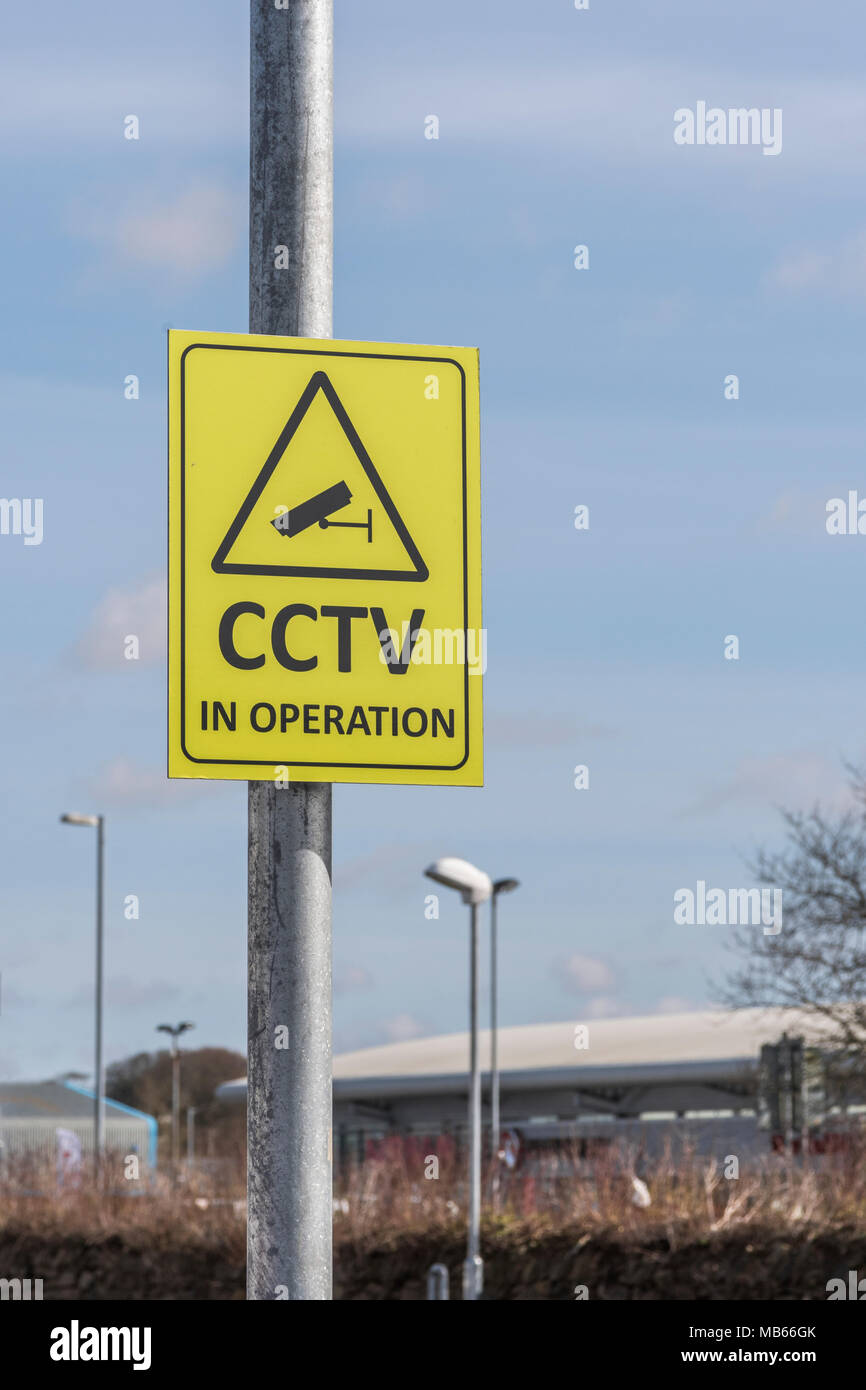 CCTV security camera in operation yellow warning sign - Watching over ...
