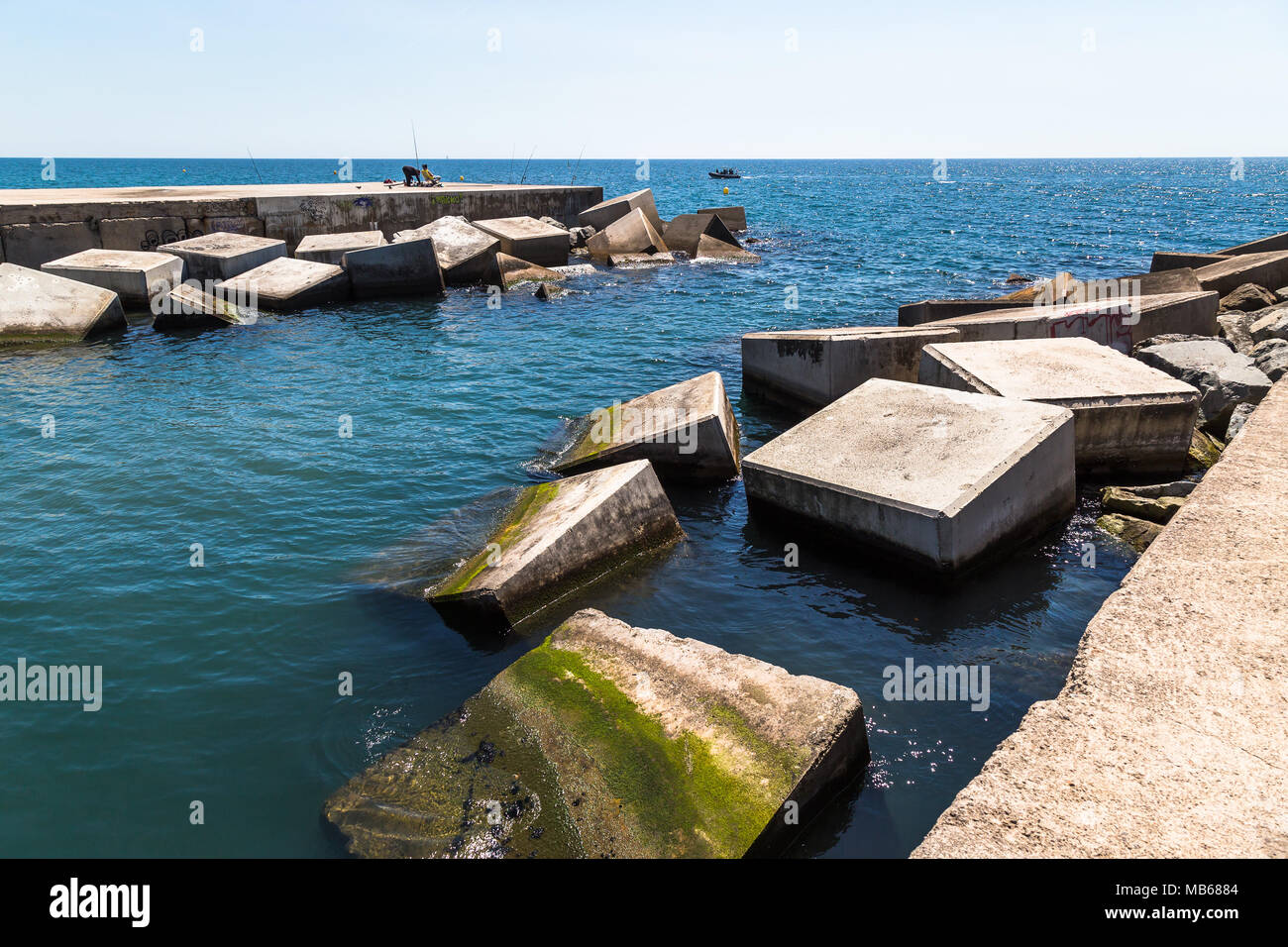 Cubic blocks of concrete form a breakwater on the beach of Nova Icaria ...