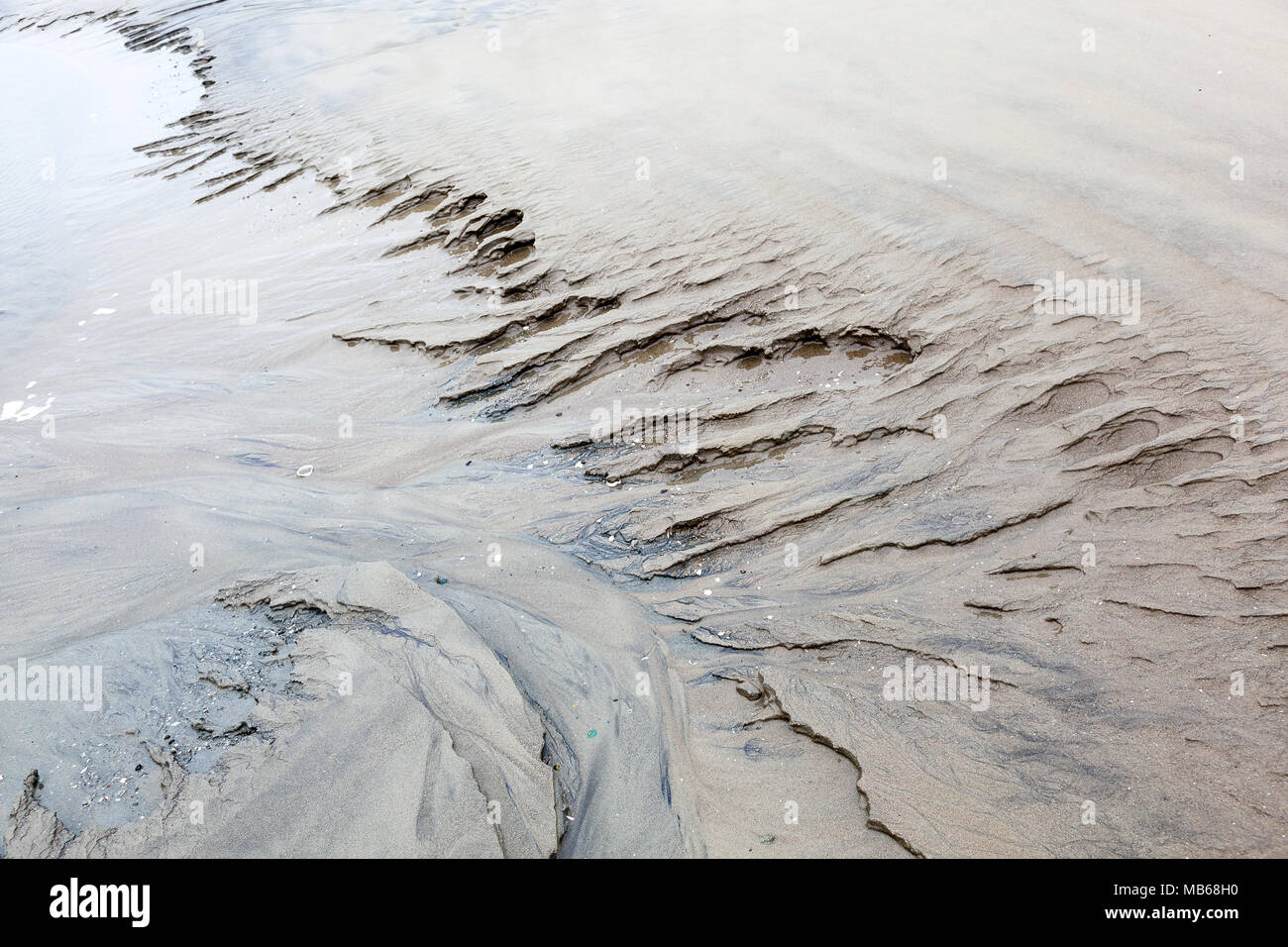 Textures and reliefs formed by water on beach sand Stock Photo - Alamy