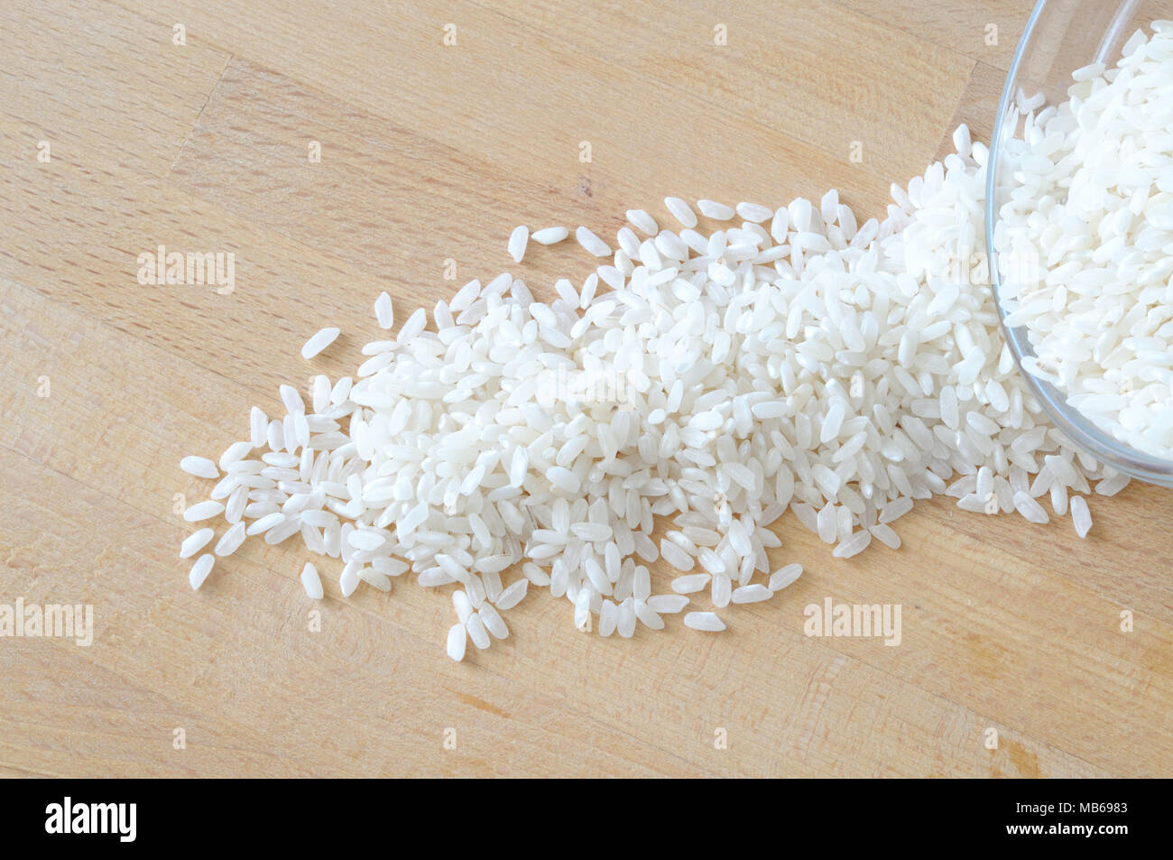 Top view of rice spilled from a bowl on a wooden table Stock Photo - Alamy