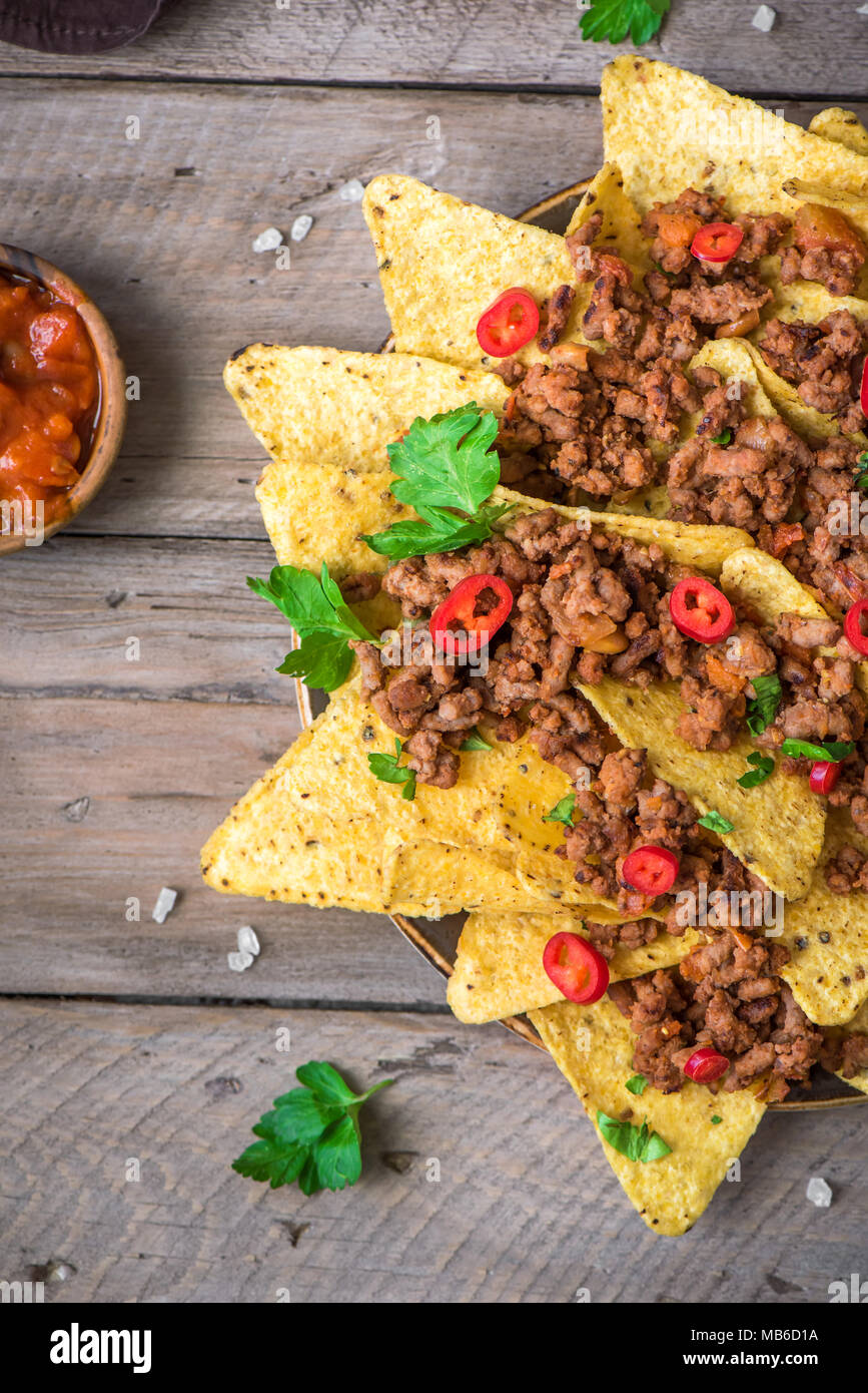 Mexican nacho corn tortilla chips with cheese, meat, guacamole and red ...