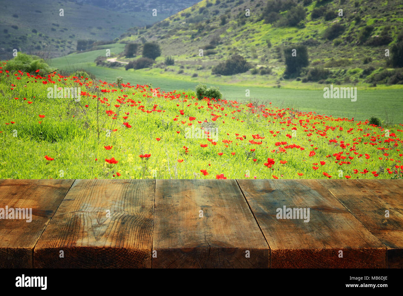wooden rustic table in front of field red poppies. product display and ...