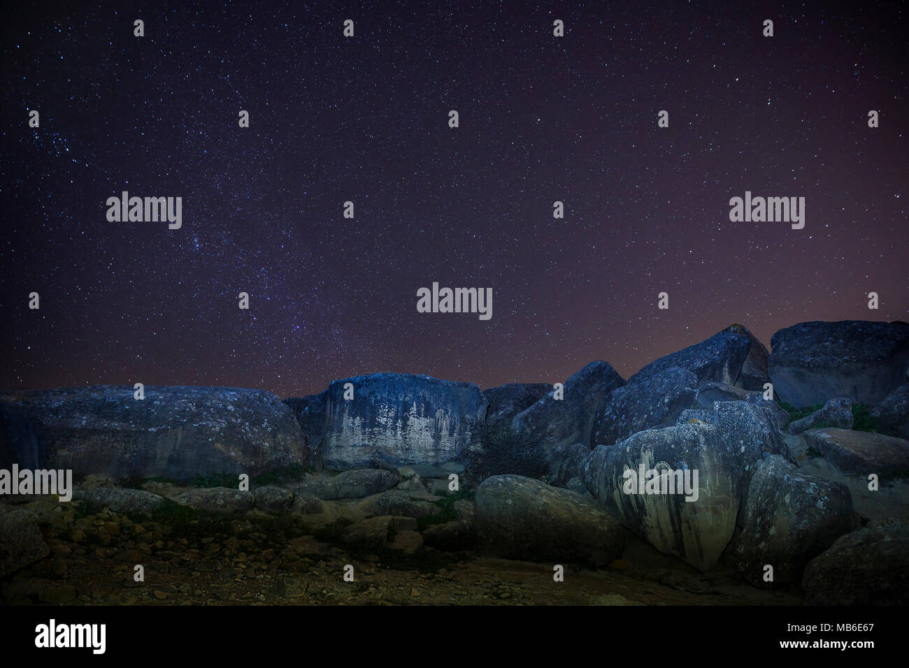 Ancient rock carvings under the stars in the night Stock Photo - Alamy