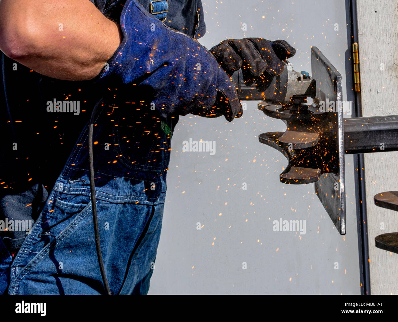Welding steel worker grinding slag and burrs from perfect spiral weld ...