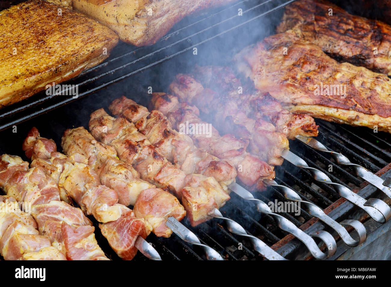 Shish kebab preparation with meat on the barbecue grill Stock Photo - Alamy