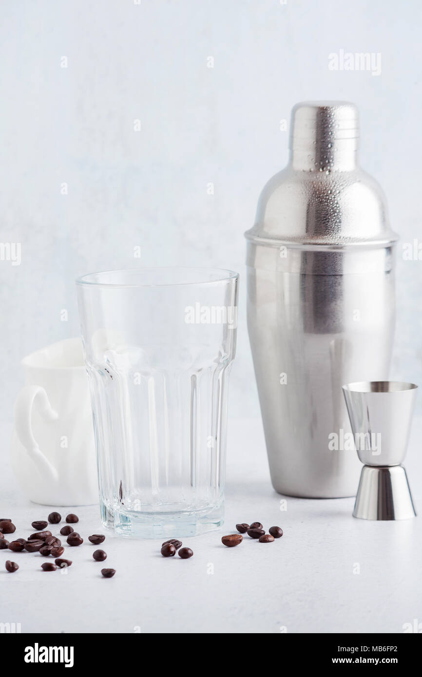 empty glasses and a milk jug with coffee beans and shaker on the table ...