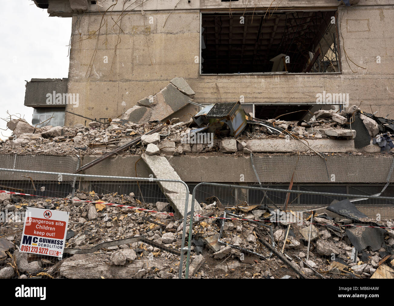 Safety fencing and warning sign in front of partly demolished ...