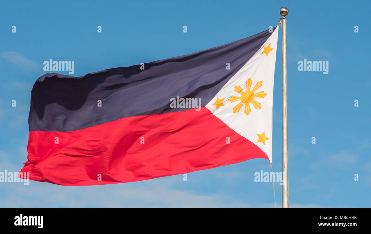 Flying bicolor flag of the Philippines with central golden sun ...