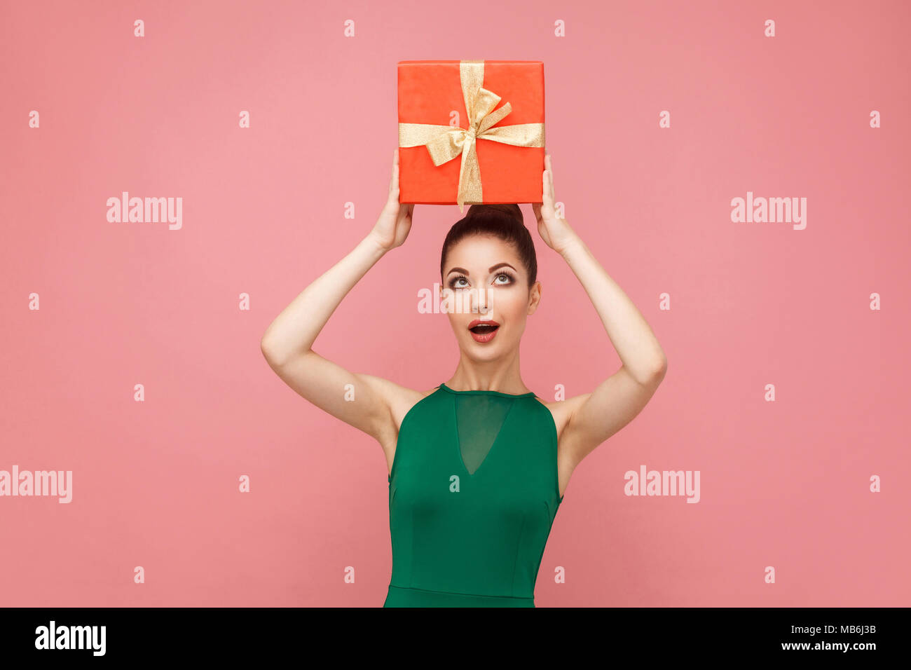 Woman holding red gift box on head. Expression emotion and feelings ...