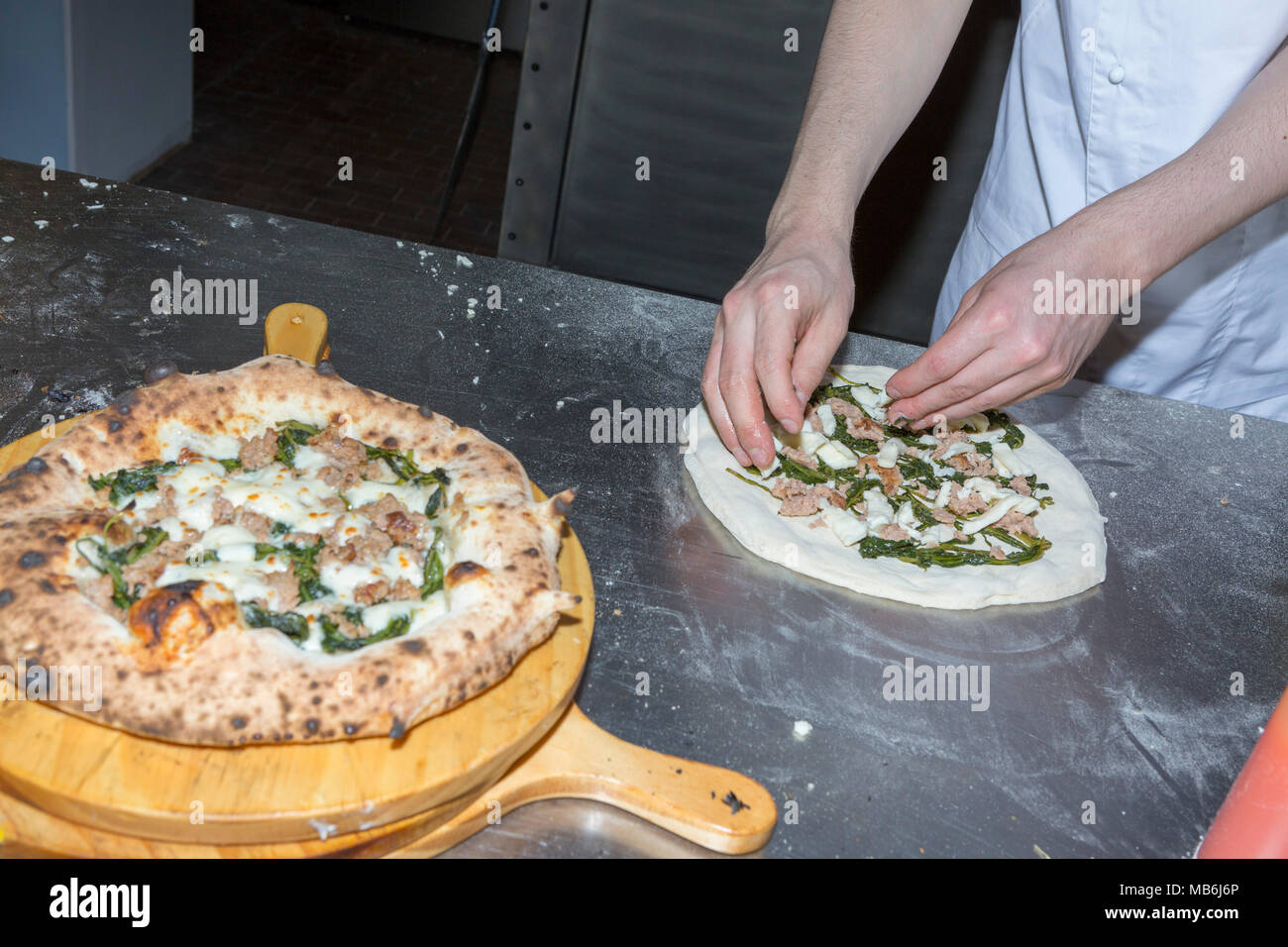 Pizza chef demonstrates making a delicious pizza Stock Photo - Alamy