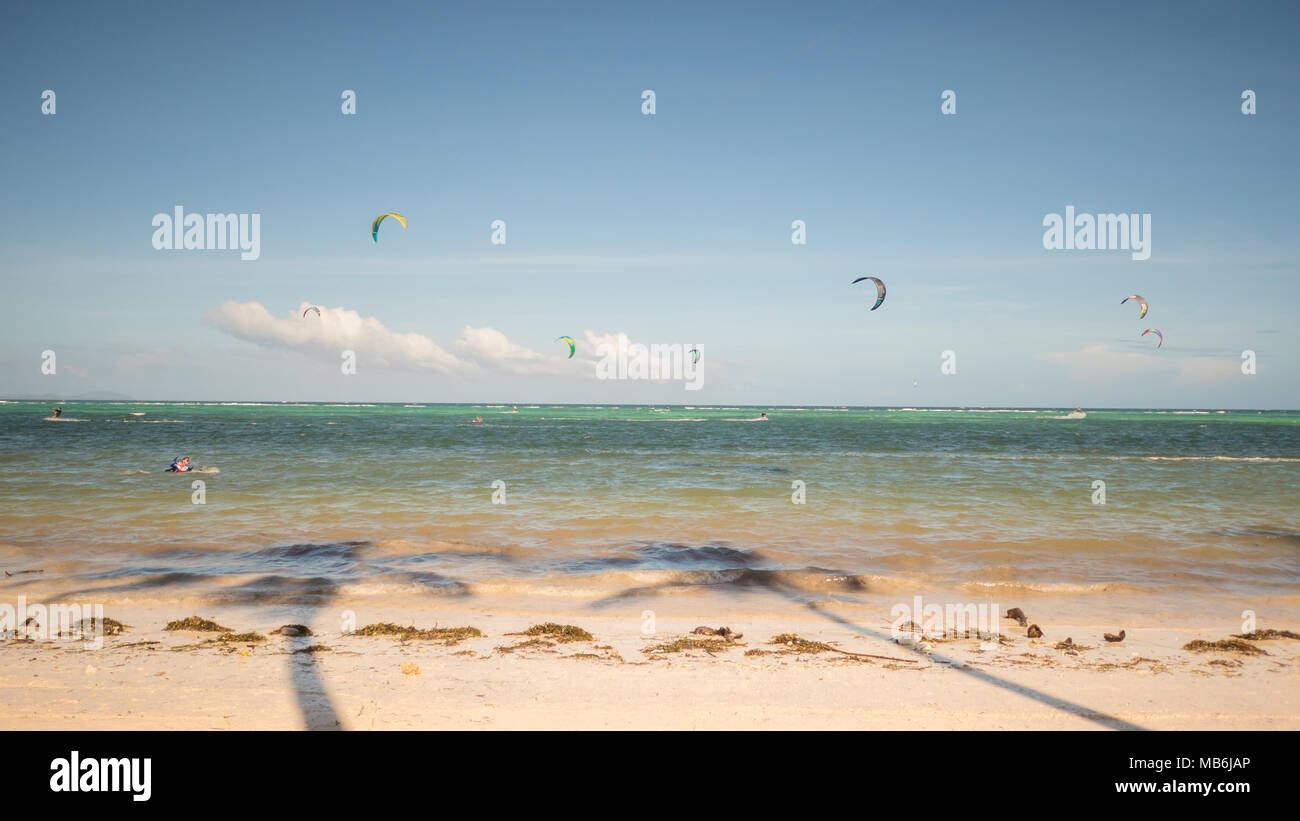 Kiteboarding. People enjoying the energy of the wind on the beach of ...
