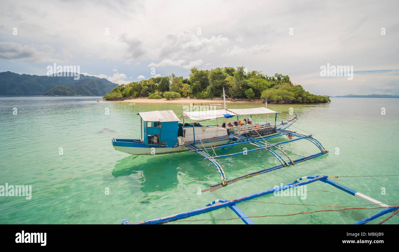 A tourist boat on the background of the island. CYC beach. Coron ...