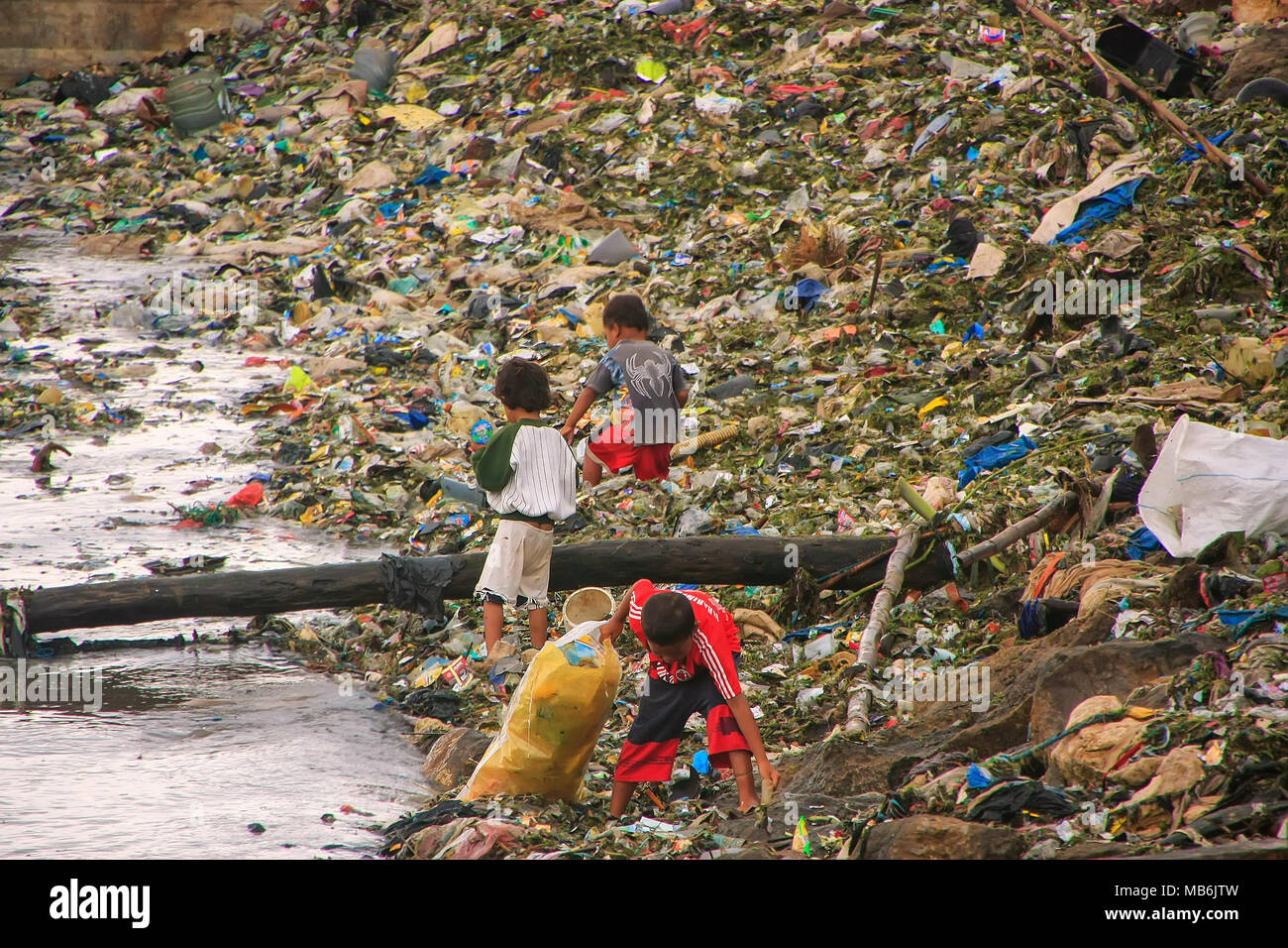 Local kids going through garbage at the sea coast in Labuan Bajo town ...