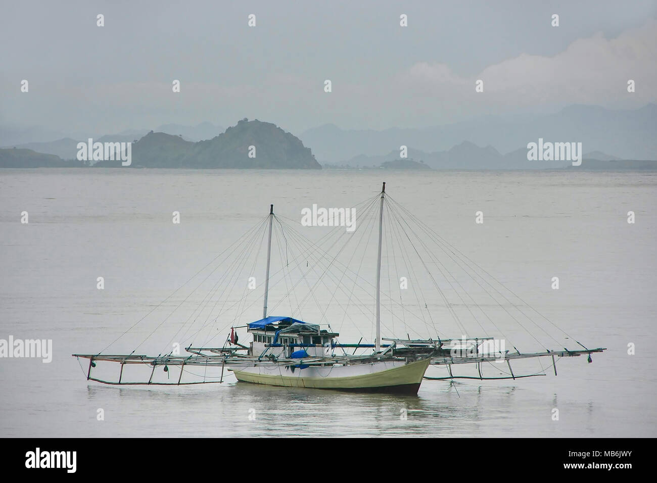 Traditional outrigger boat anchored at Labuan Bajo town on Flores ...