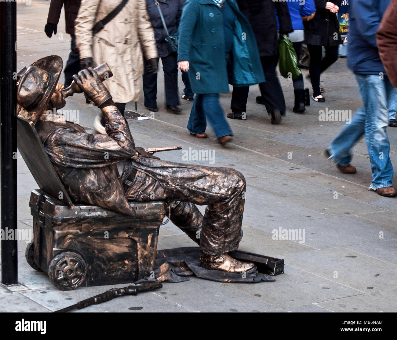 Pedestrians walking past living sculpture street artist Stock Photo - Alamy