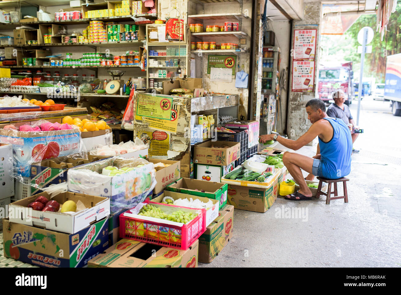 People sitting in front of the shop on the streets of Hong Kong Stock ...