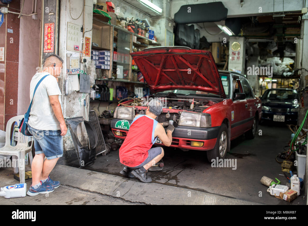 Man fixing a car in a car shop on the streets of Hong Kong Stock Photo ...