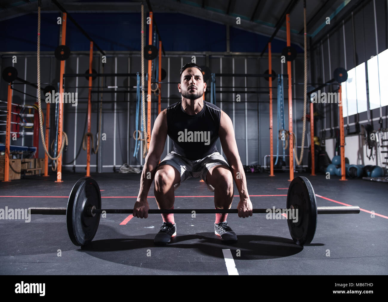Athletic man works out at the gym with a barbell Stock Photo - Alamy