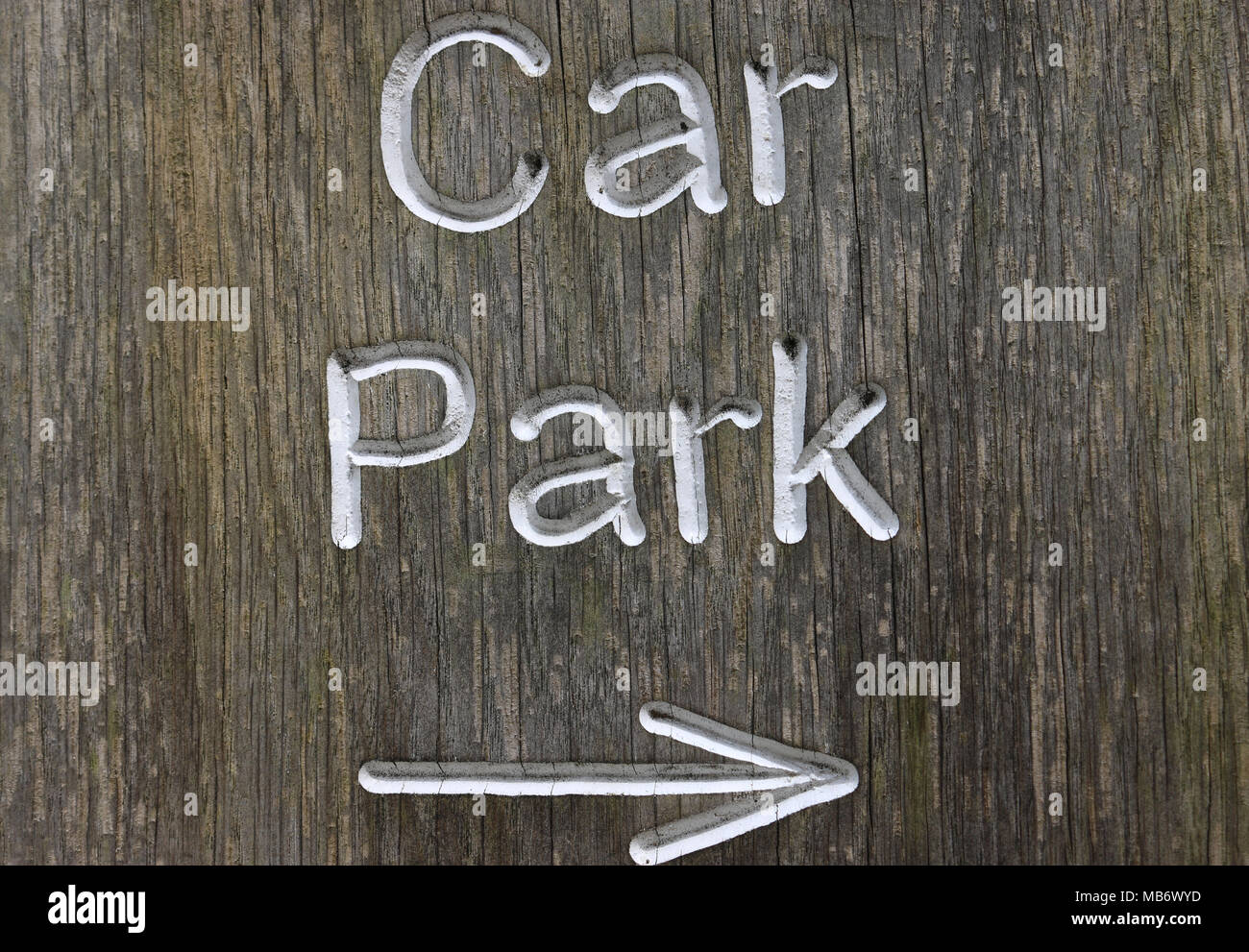 Rustic car park directional sign routed into well grained wood and with ...
