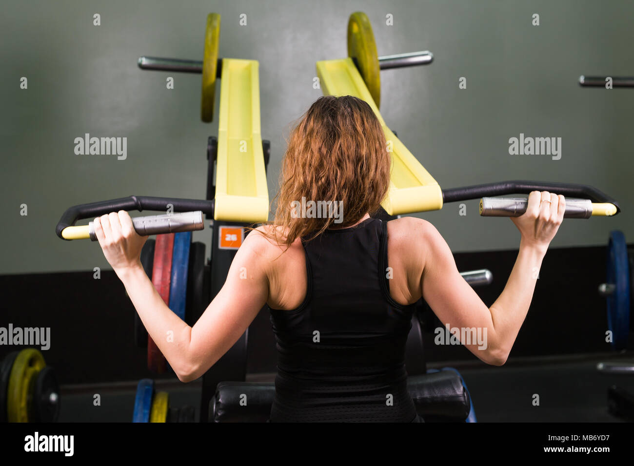 Gym fitness club indoor with young woman training, rear view Stock ...