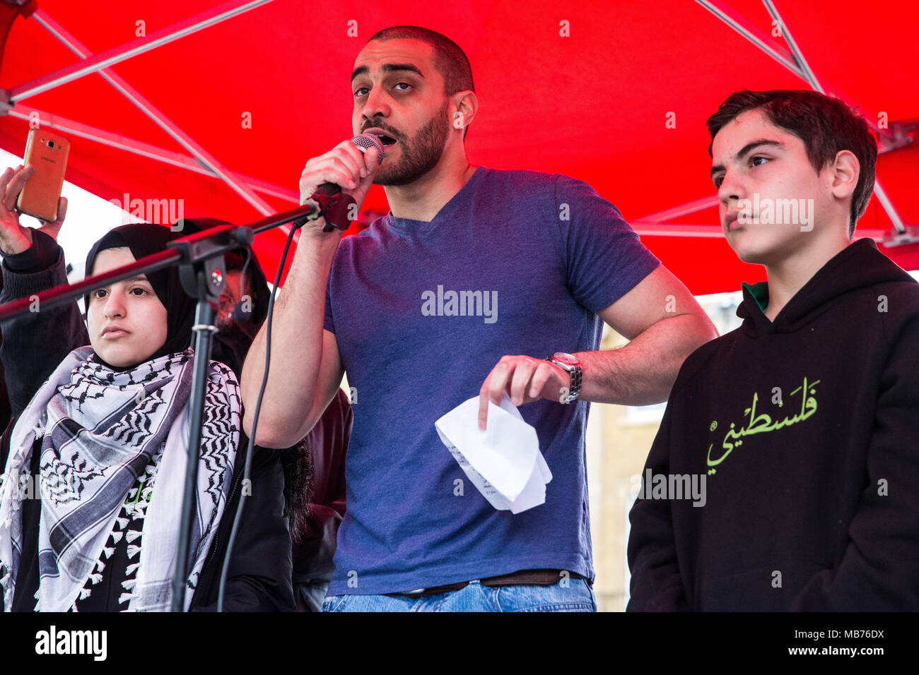 London, UK. 7th April, 2018. Rapper Lowkey joins two children to read ...