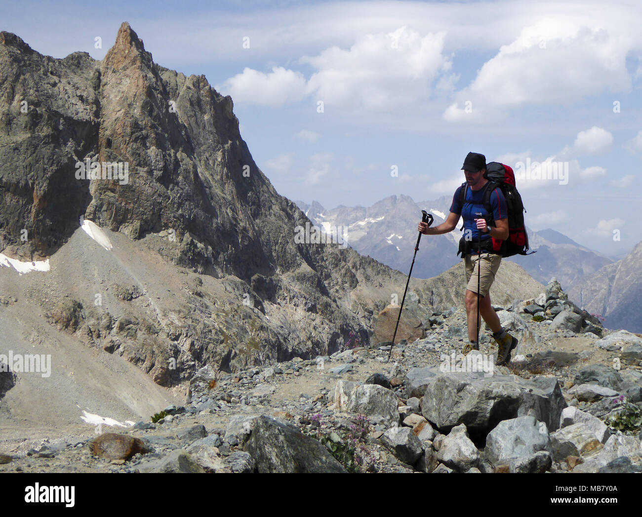tall athletic male climber on the approach hike to a remote base camp ...