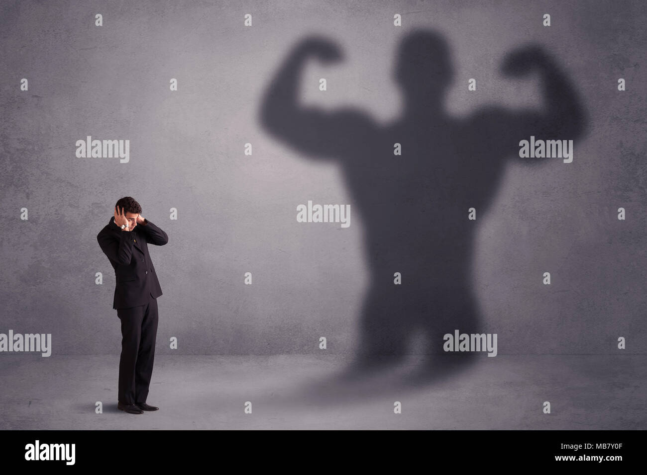 Business man looking at his own strong fit shadow concept on background ...