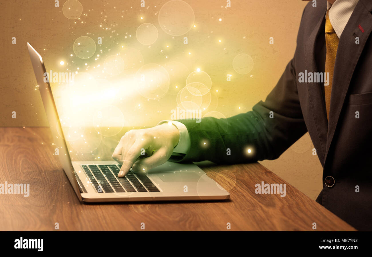 An elegant businessman sitting at desk and pushing the buttons of his ...