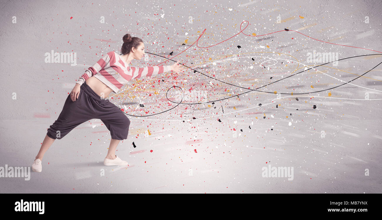 A young contemporary energetic dancer in action in front of a grey wall ...
