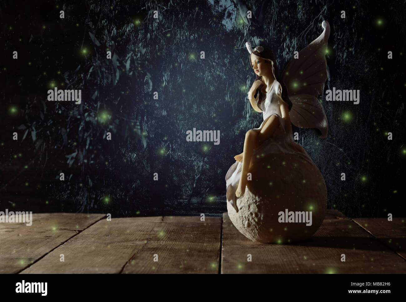 image of magical little fairy in the forest sitting over the stone ...