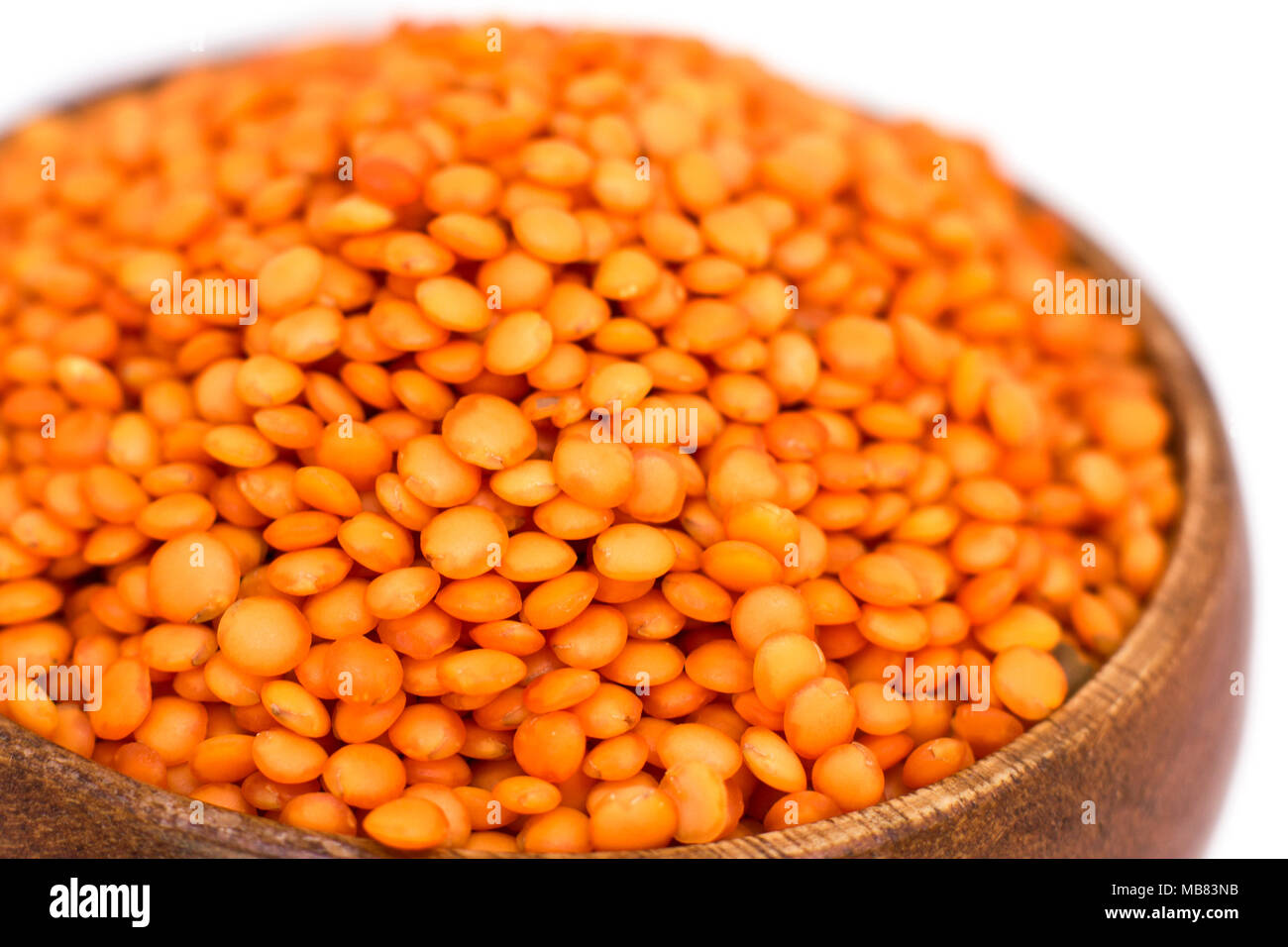 Red raw lentils in a wooden bowl. Isolated on the white background Stock Photo - Alamy