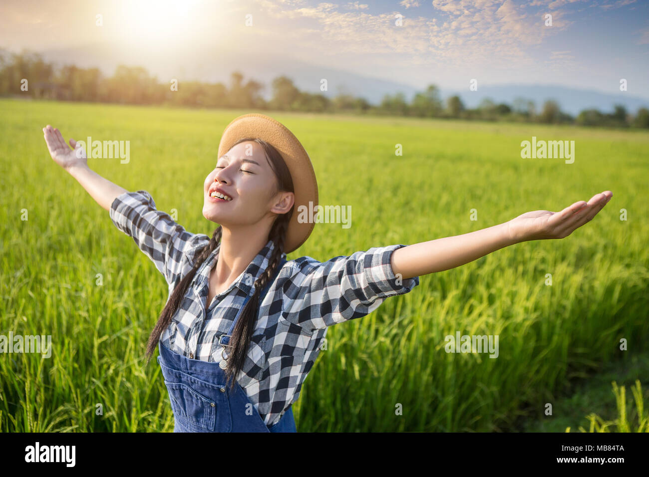 Happy farmer waving in rice paddies Stock Photo - Alamy