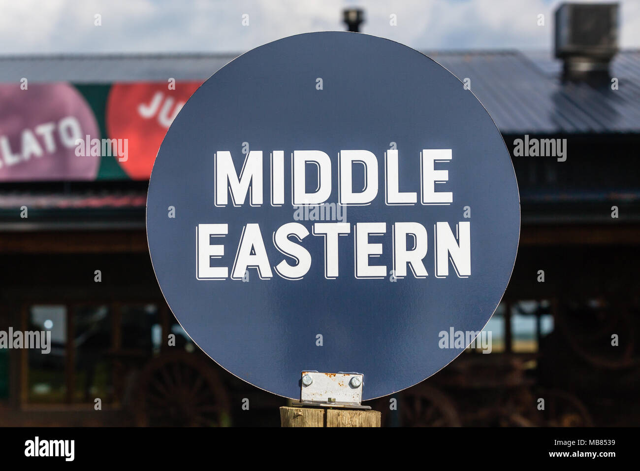 Middle Eastern word white letters on blue round disk sign board outside ...