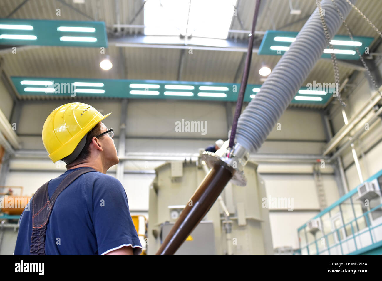 operator installs a transformer in an industrial plant in mechanical ...