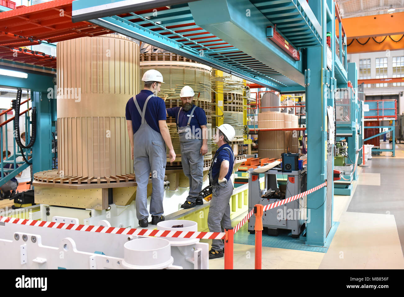 group worker assembles a transformer in mechanical engineering ...