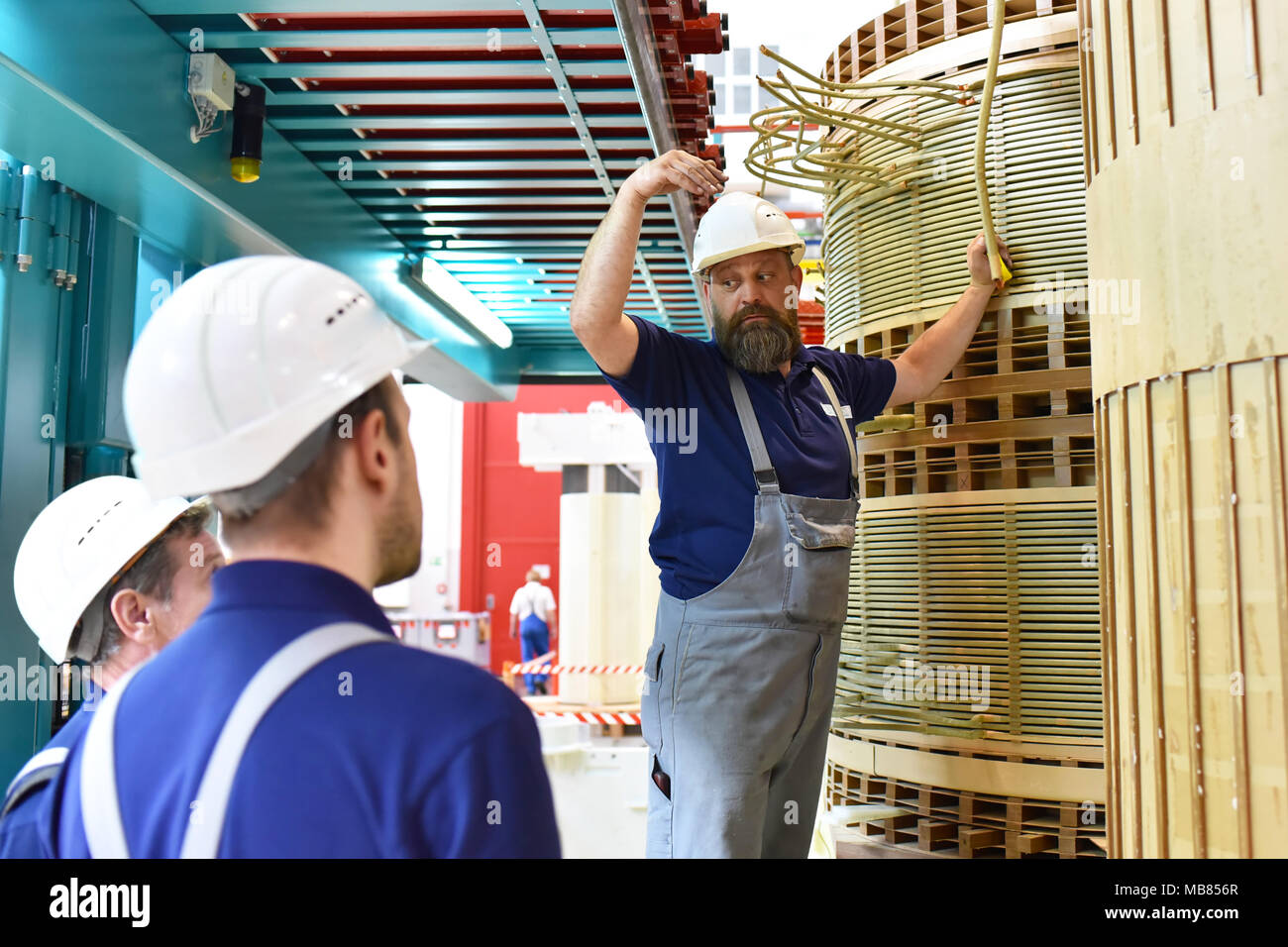 group worker assembles a transformer in mechanical engineering ...