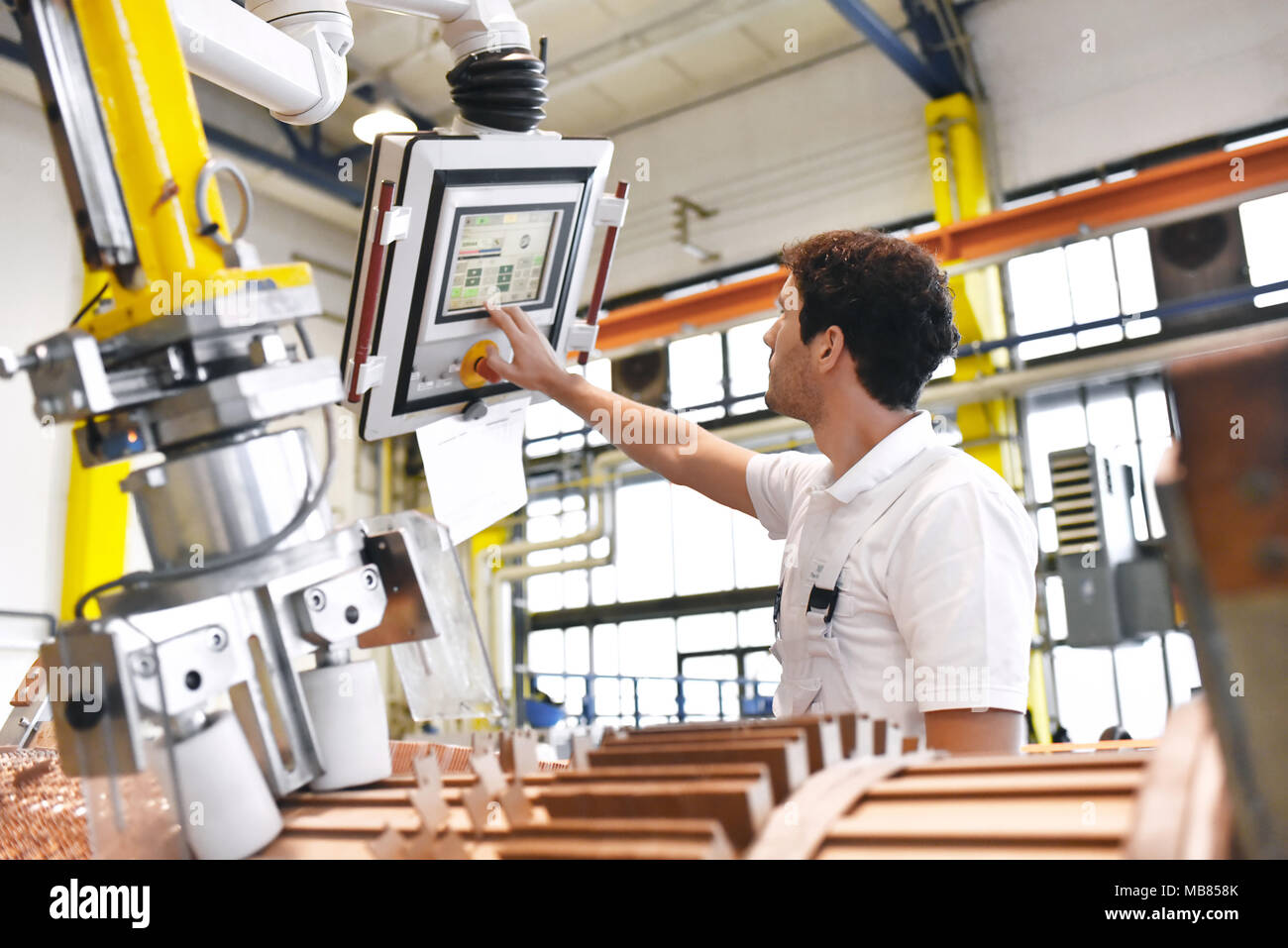 young mechanical engineering workers operate a machine for winding ...