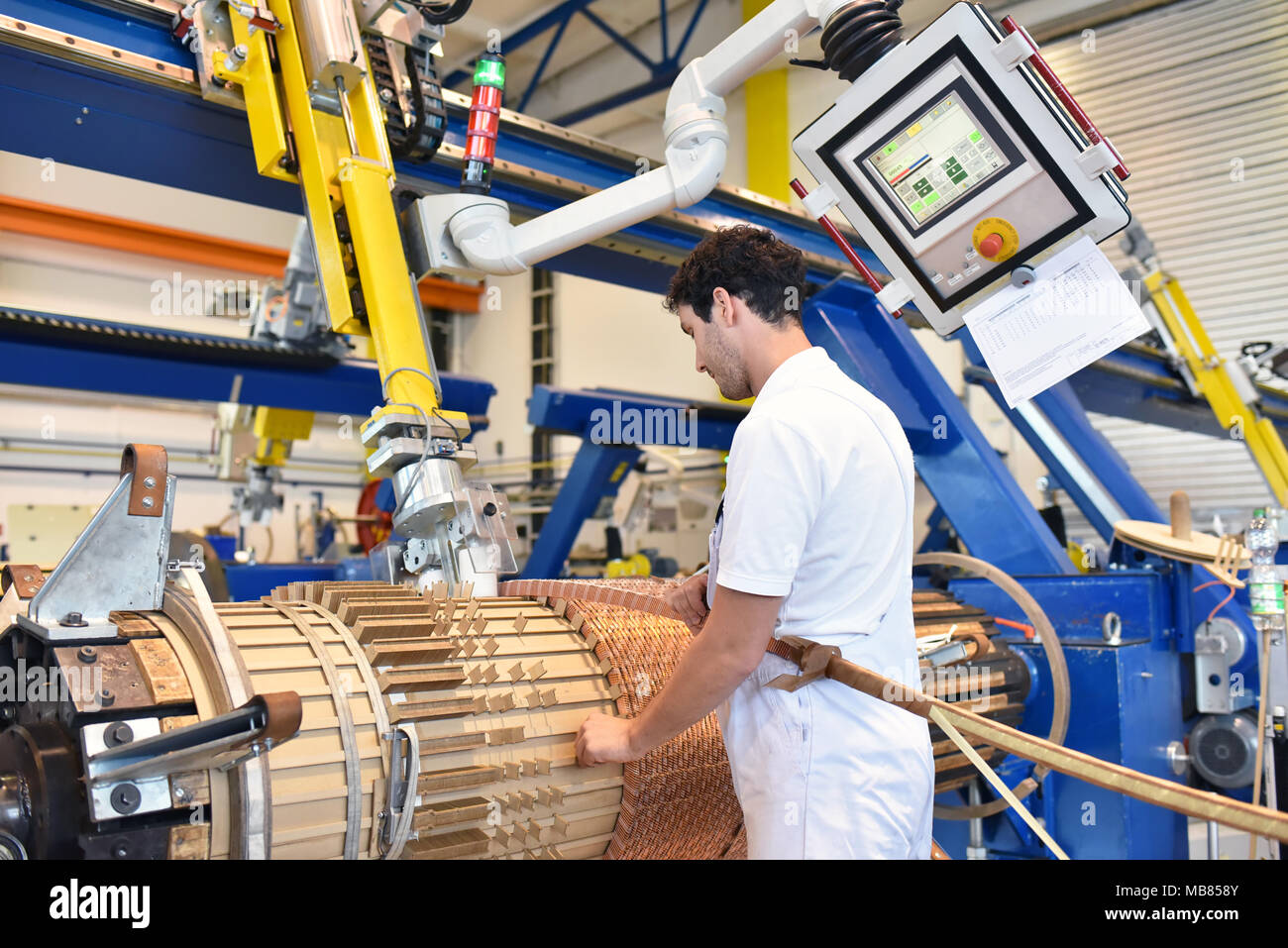 young mechanical engineering workers operate a machine for winding ...