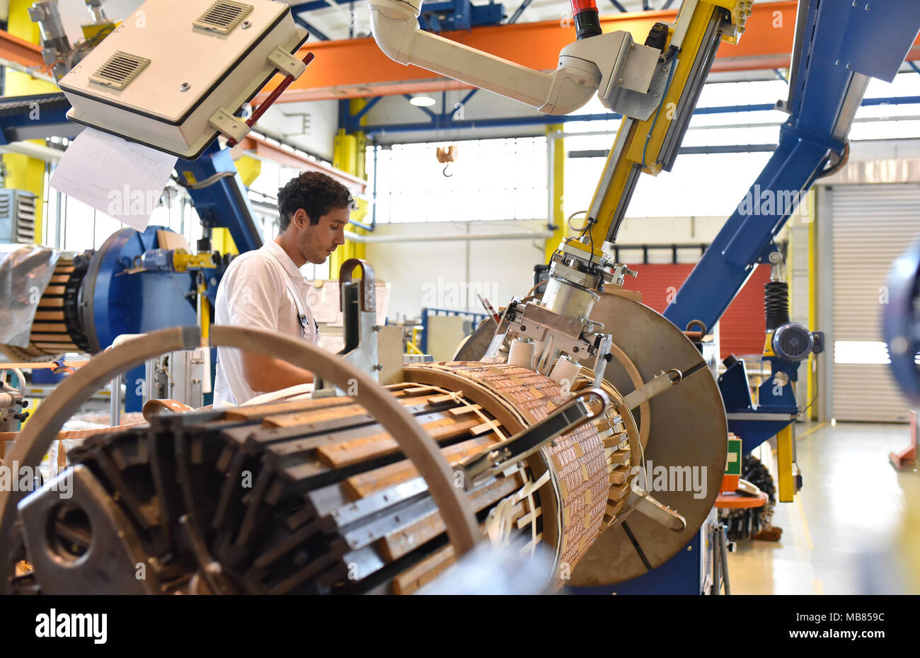 young mechanical engineering workers operate a machine for winding ...