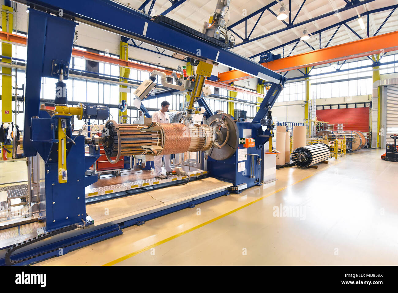 young mechanical engineering workers operate a machine for winding ...